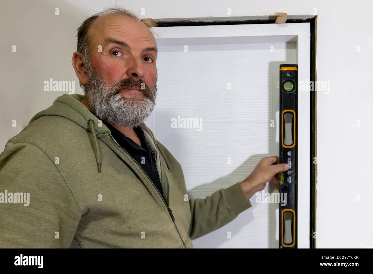 A worker's hands with spirit level against frame of the door. Home ...