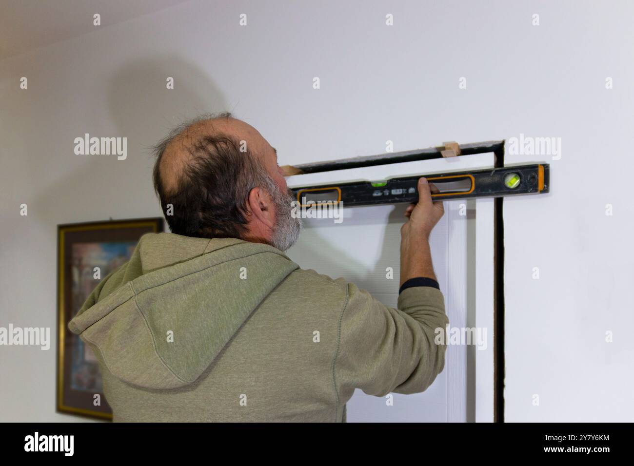 A worker's hands with spirit level against frame of the door. Home ...
