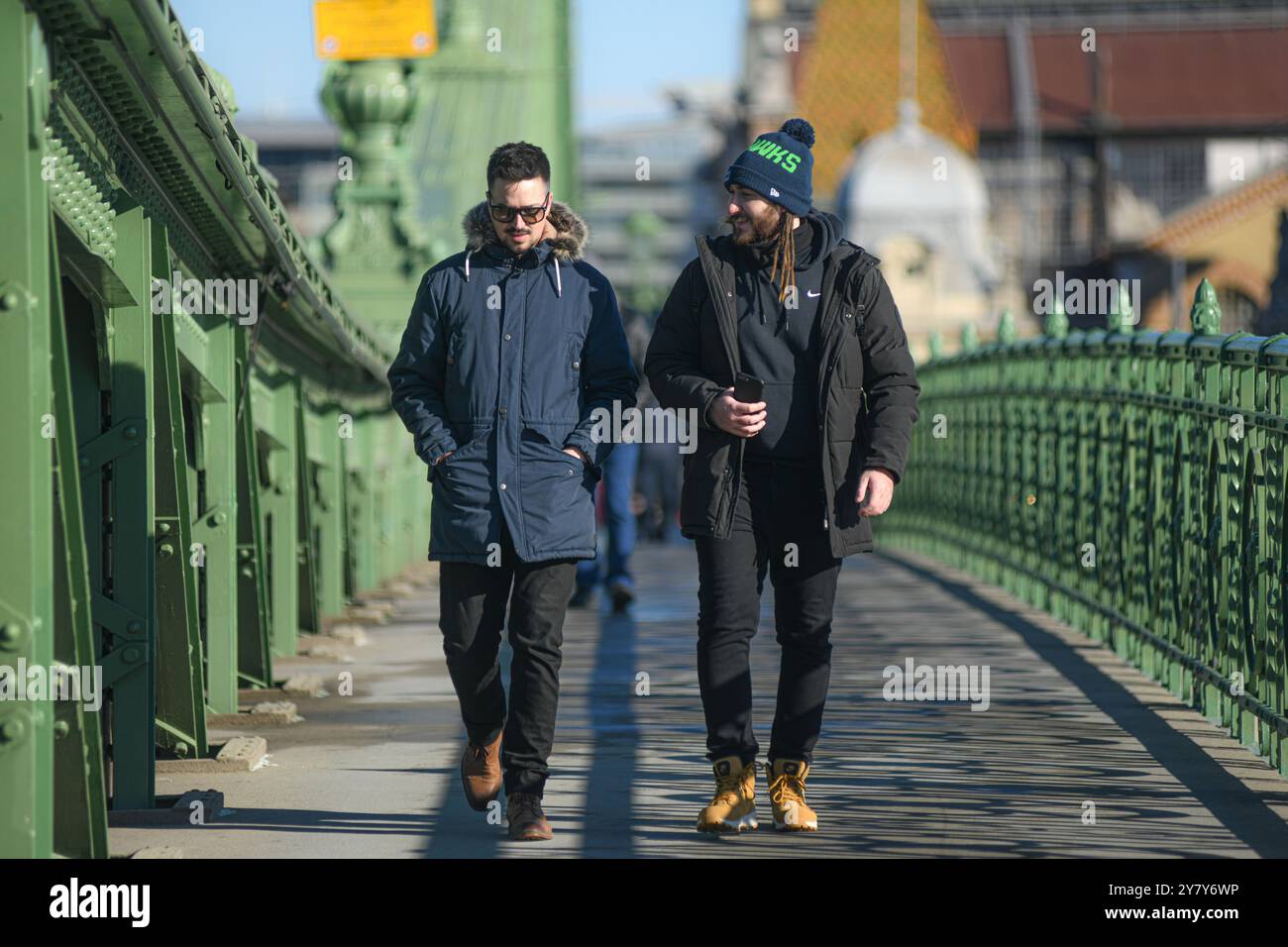Hungarian men walking through the Liberty Bridge during winter ...