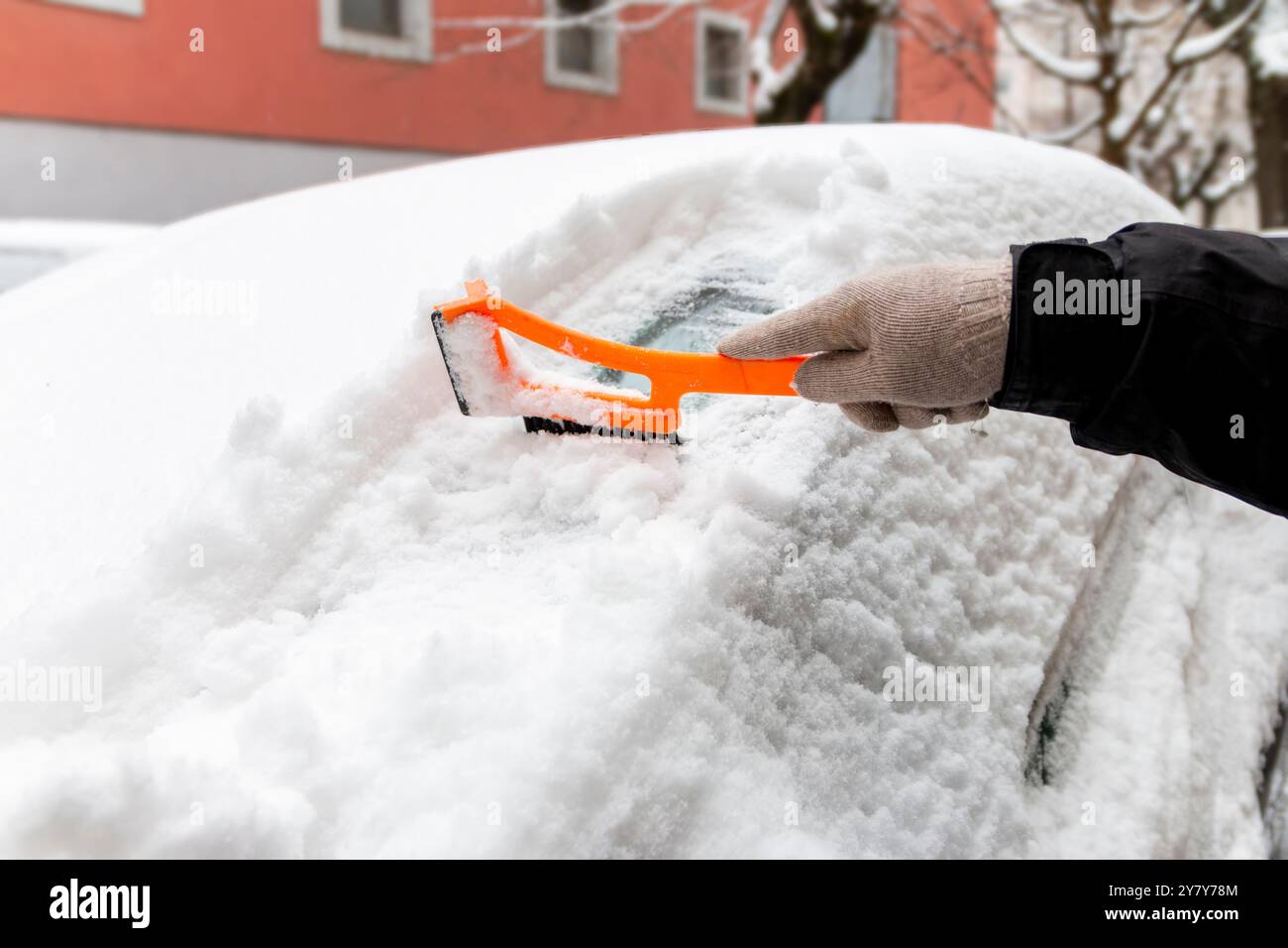 Winter season driving. Close-up of a hand cleaning a vehicle's ...