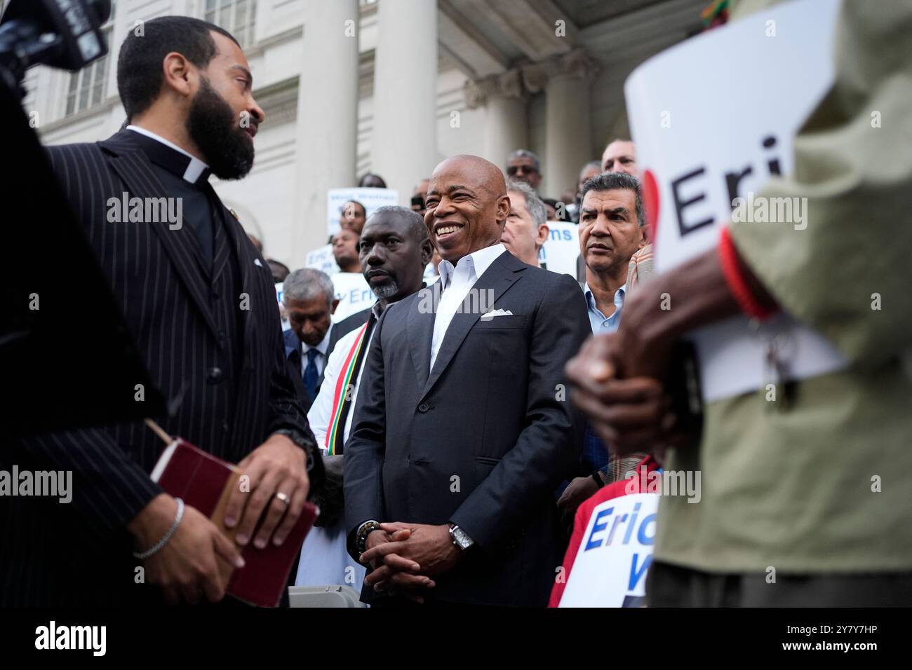 New York City Mayor Eric Adams is surrounded by faith leaders and other ...