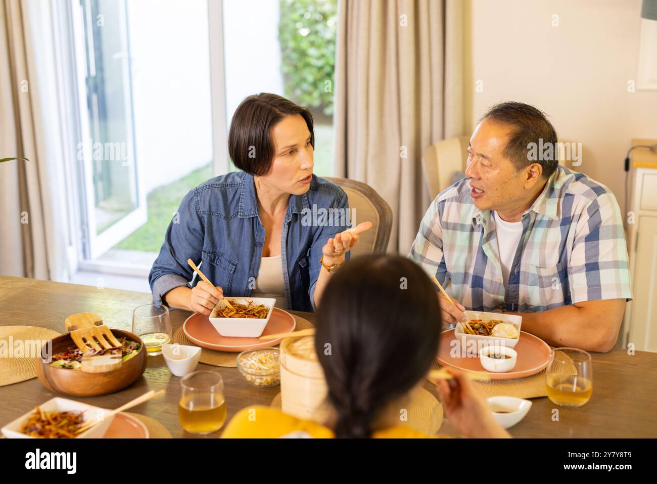 At home, Eating together, asian family enjoying meal and conversation ...