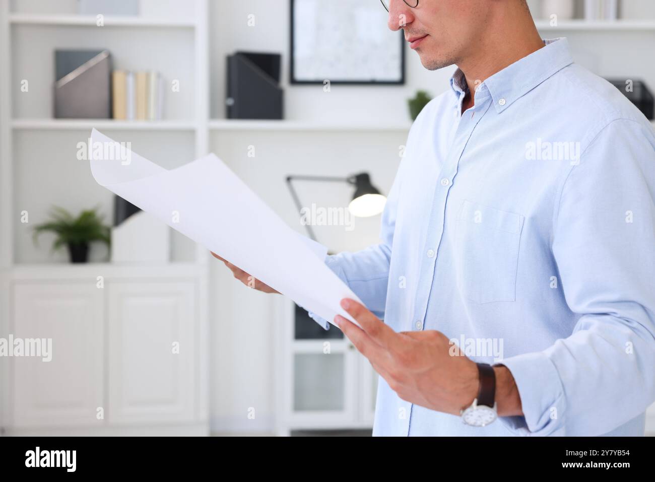 Architect holding paper sheet with engineering drawing in office ...