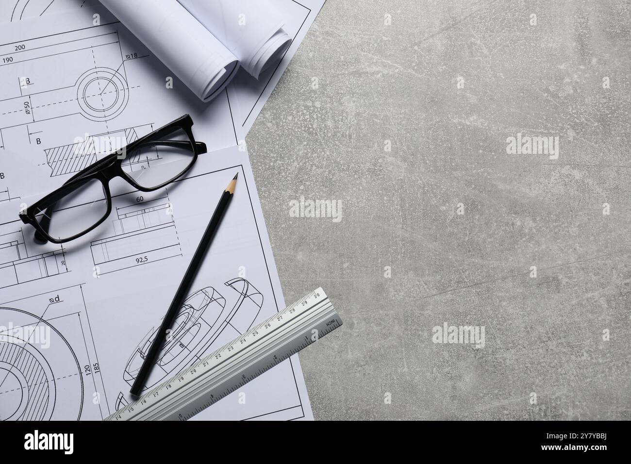 Different engineering drawings, ruler, pencil and glasses on gray ...