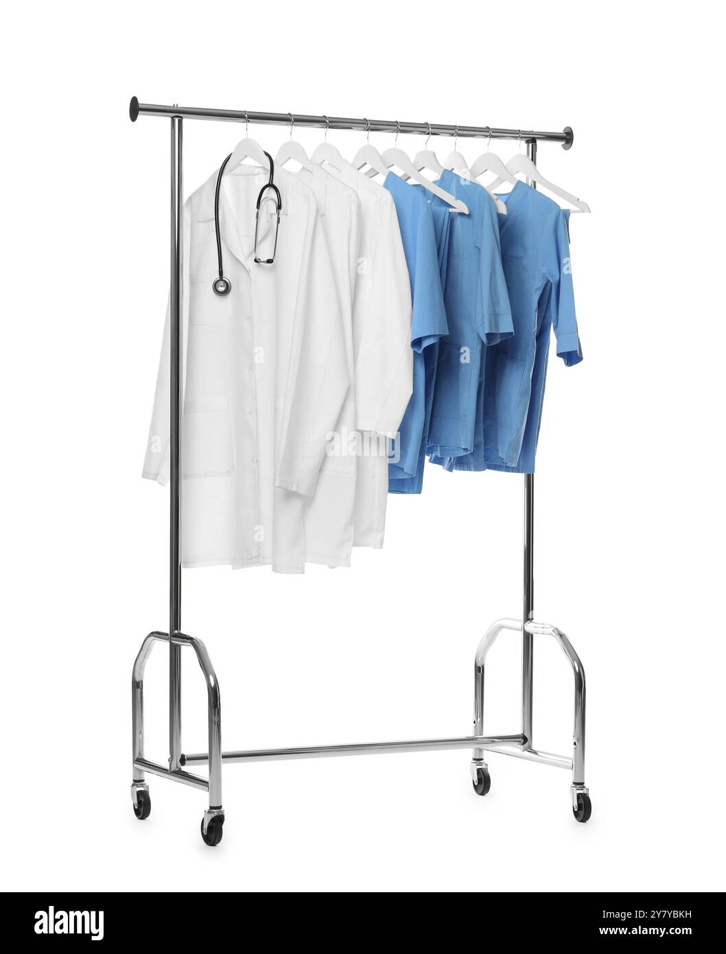 Different medical workers' uniforms and stethoscope on clothing rack ...