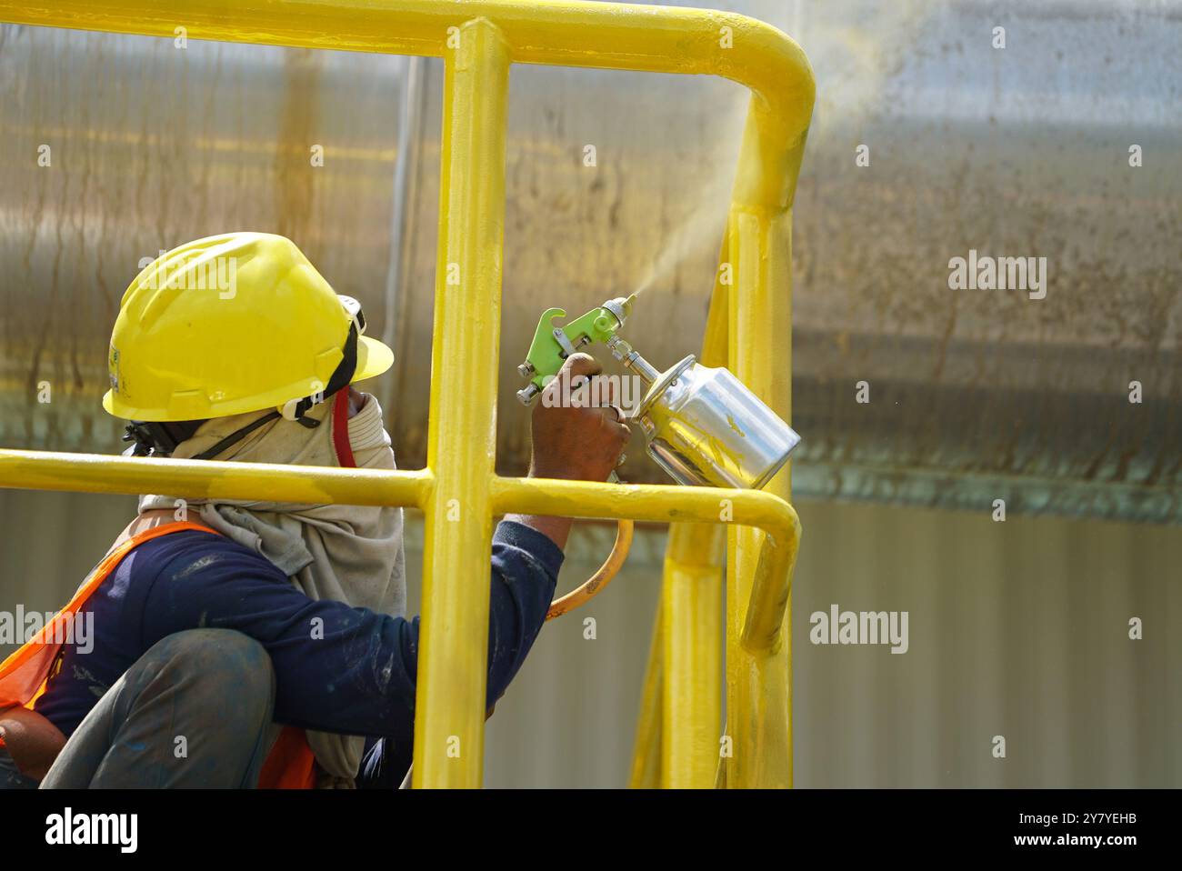 Spray painting Yellow color to the steel by the worker Stock Photo - Alamy