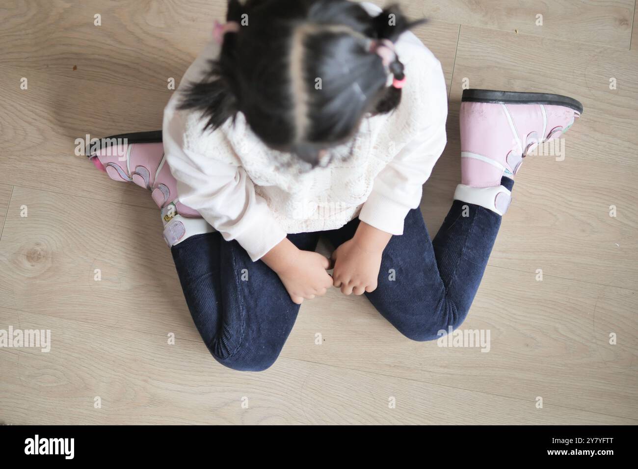 child sitting W posture on the floor Stock Photo - Alamy