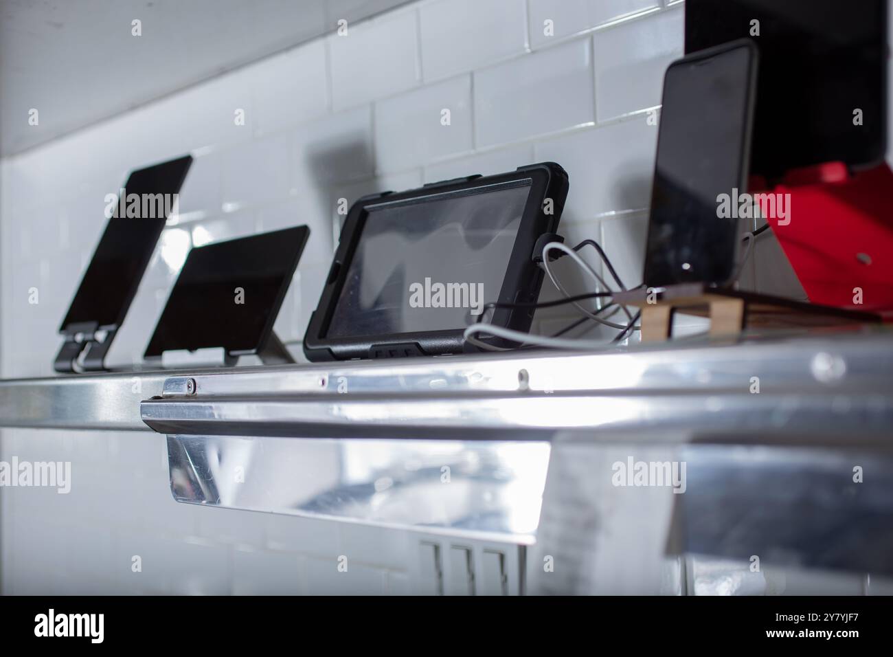 A view of several tablets used for food app deliveries, seen on a shelf ...