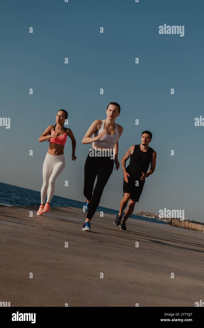 Three young people in sportswear looking concentrated while running ...