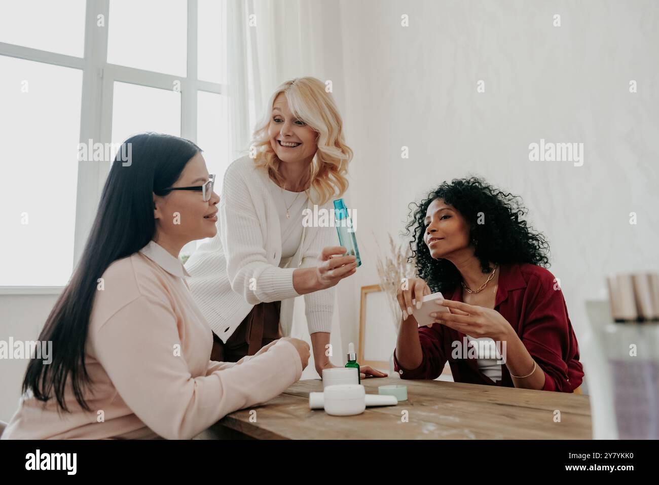 Happy mature woman advising beauty products to her friends while ...