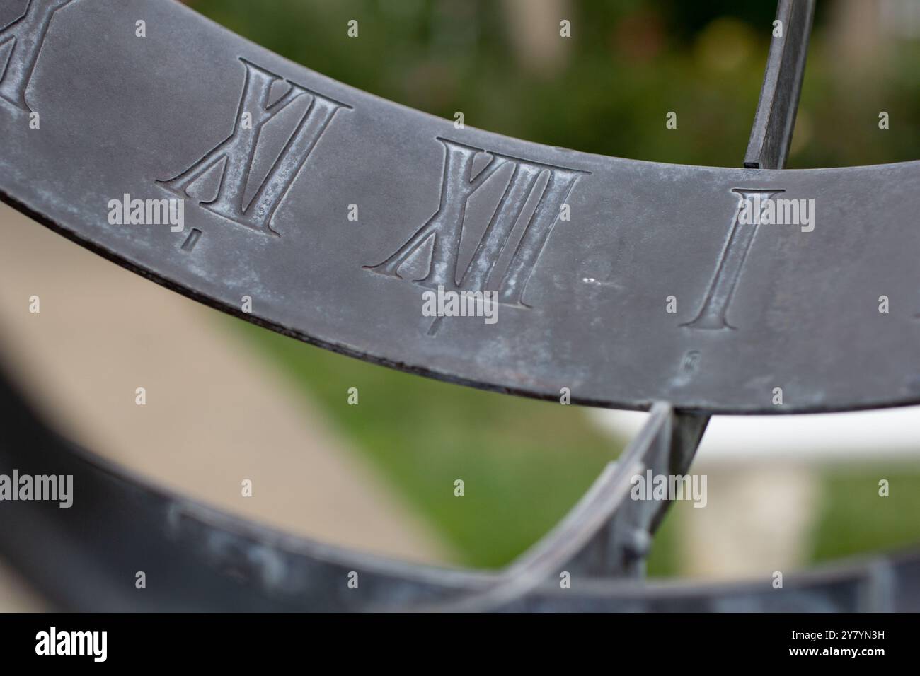 A closeup view of a metal sundial, featuring the Roman numerals Stock ...