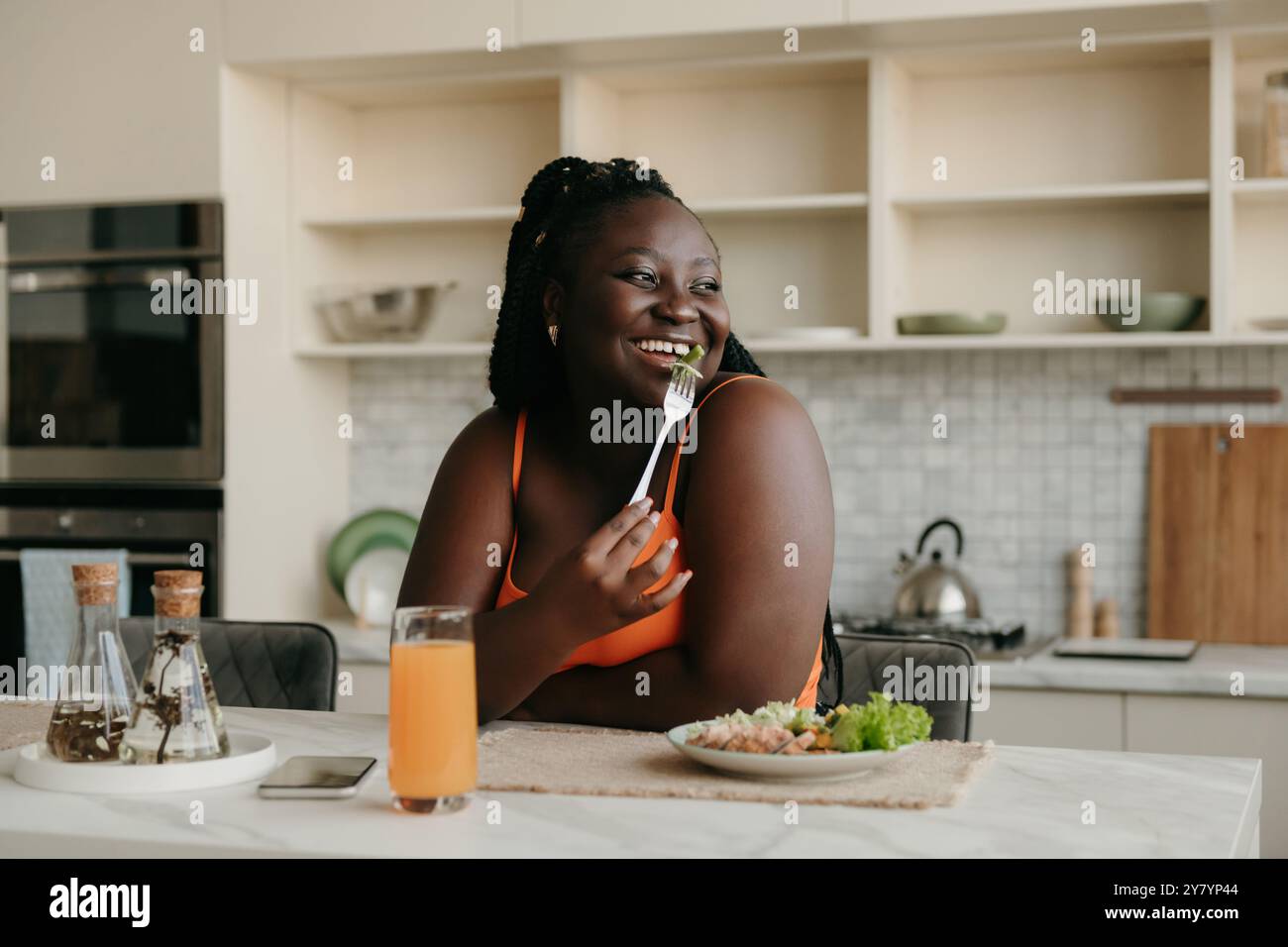 Beautiful curvy African woman enjoying healthy food for lunch at the ...