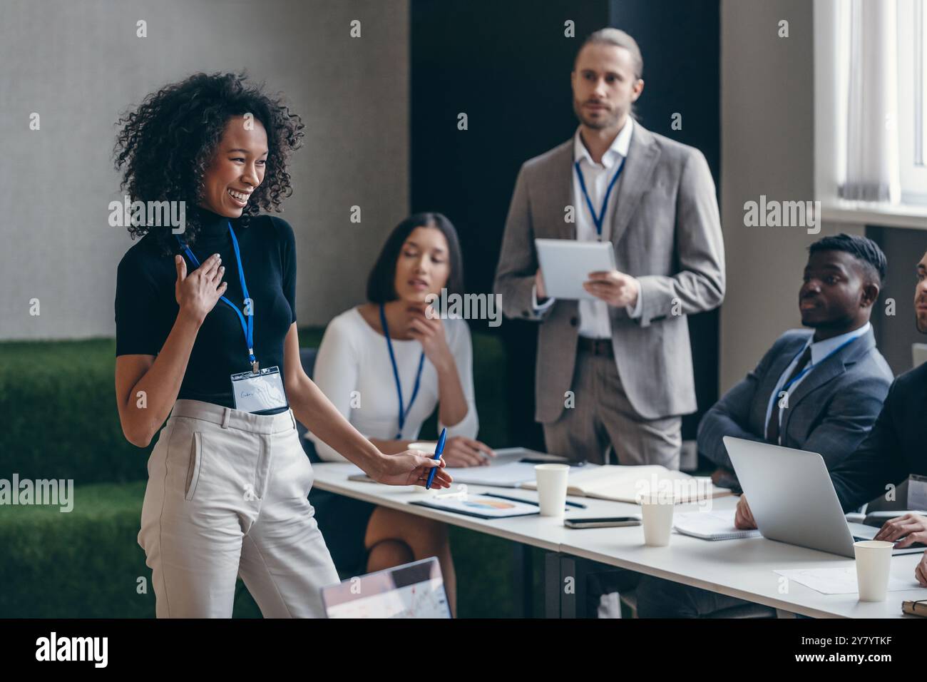 Happy African female speaker talking to audience during a business ...