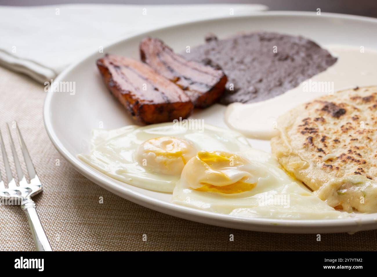 A view of a Latin American breakfast plate, featuring sunny side up ...