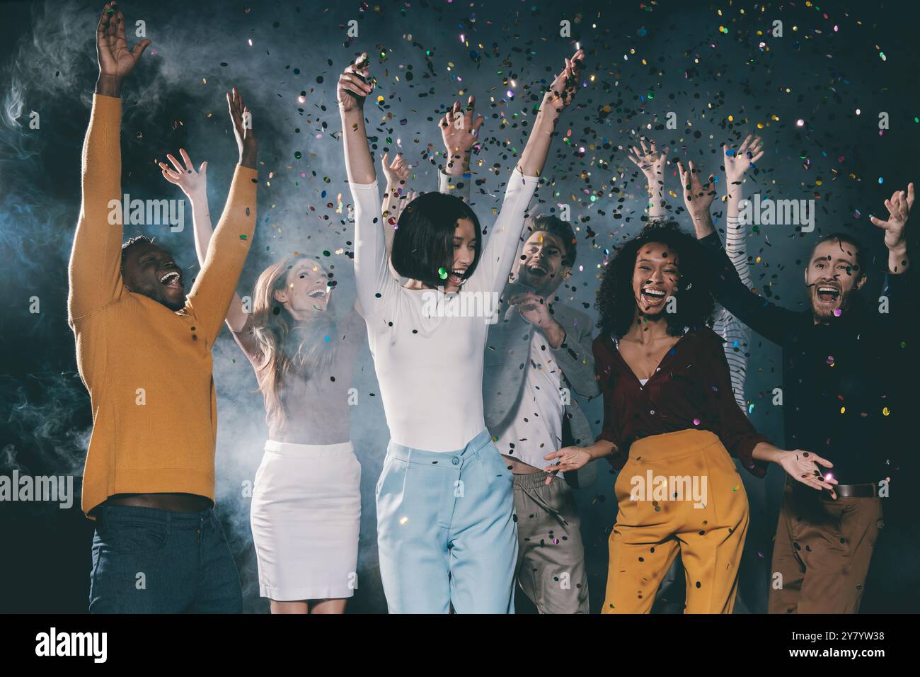 Group of young happy people dancing and throwing confetti while having ...