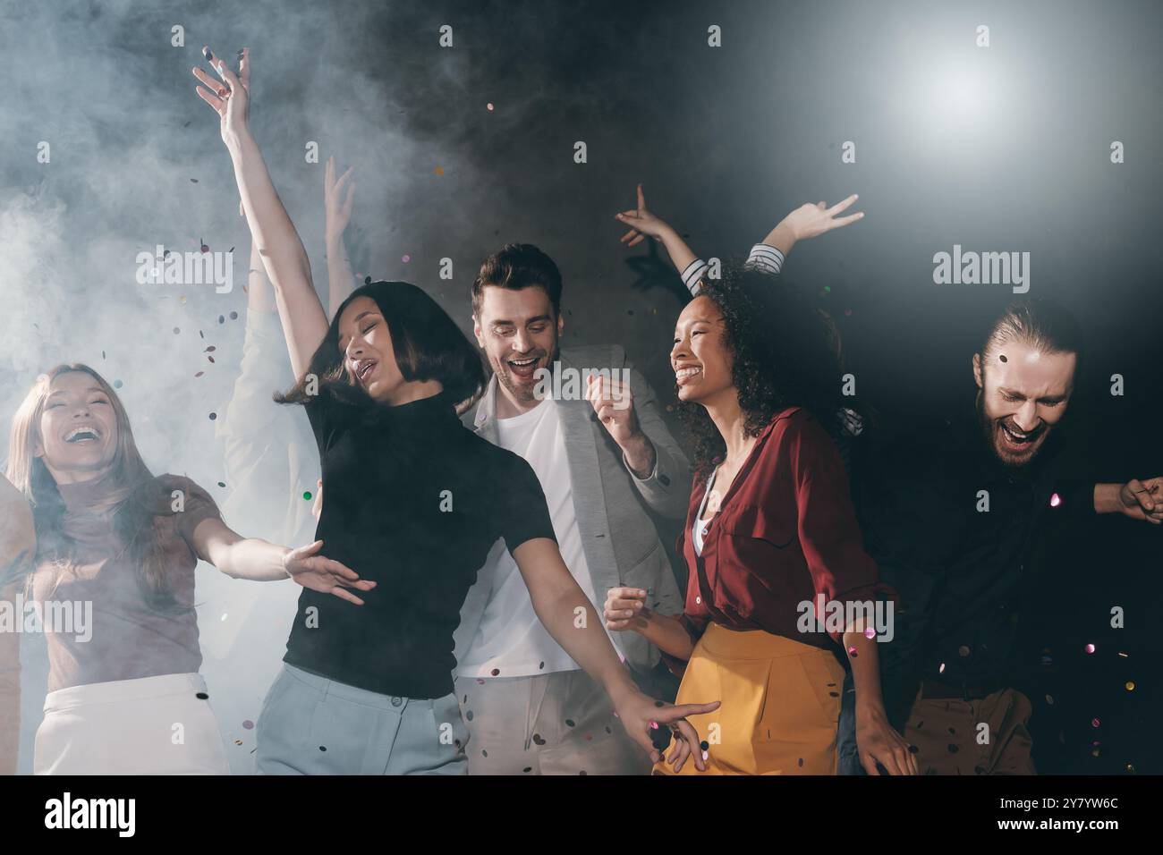 Group of happy young friends dancing and having fun in night club ...