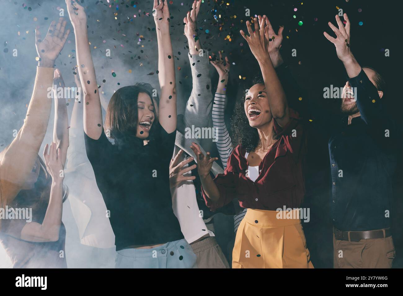 Group of happy young people dancing and throwing confetti while having ...