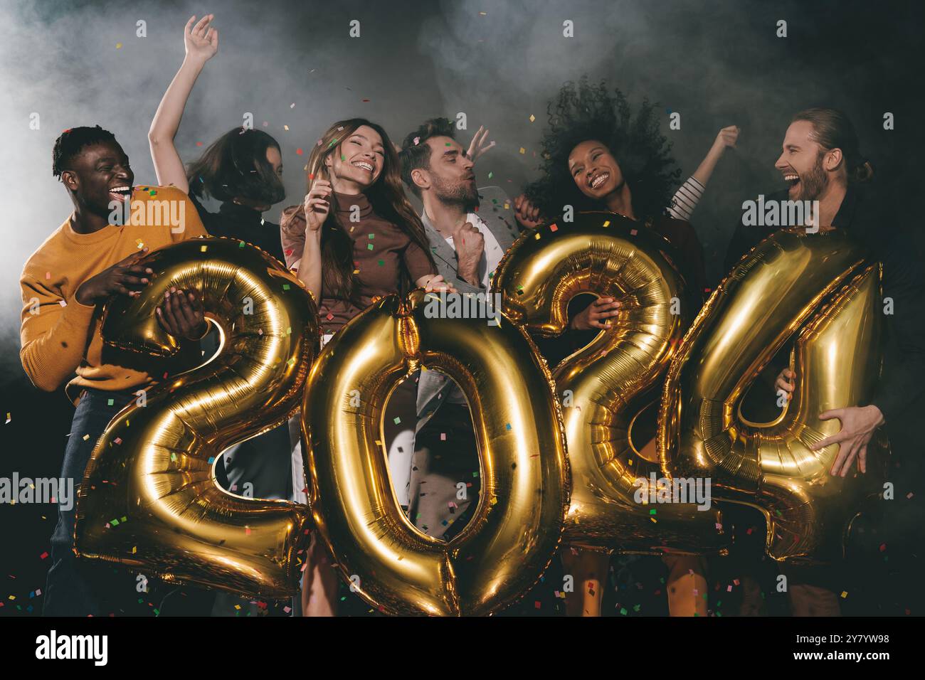 Group of joyful young people celebrating 2024 New Year while dancing ...