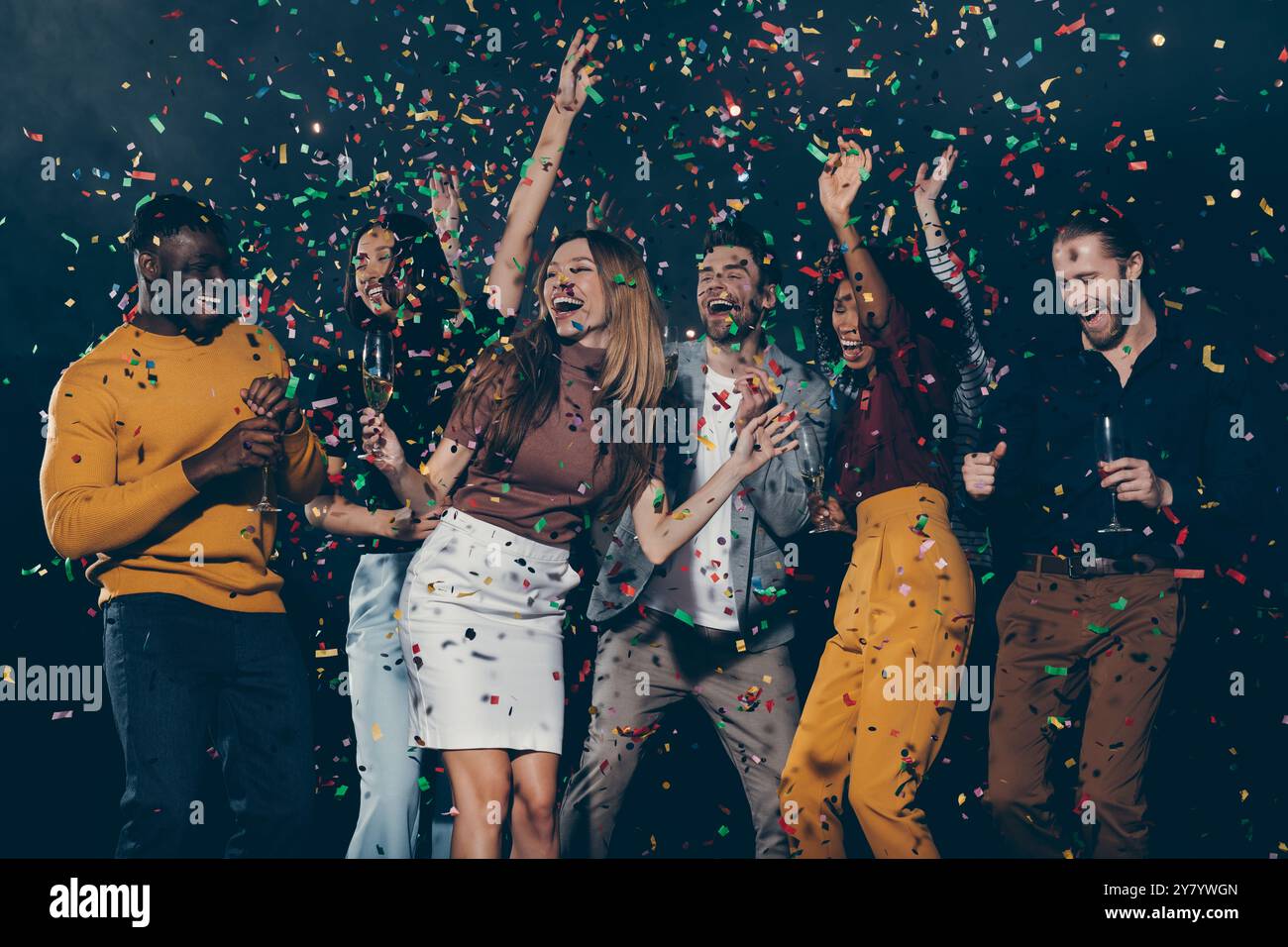 Group of young happy people enjoying champagne and throwing confetti ...