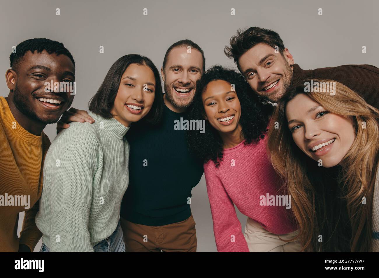 Joyful young people bonding and smiling while making selfie on beige ...