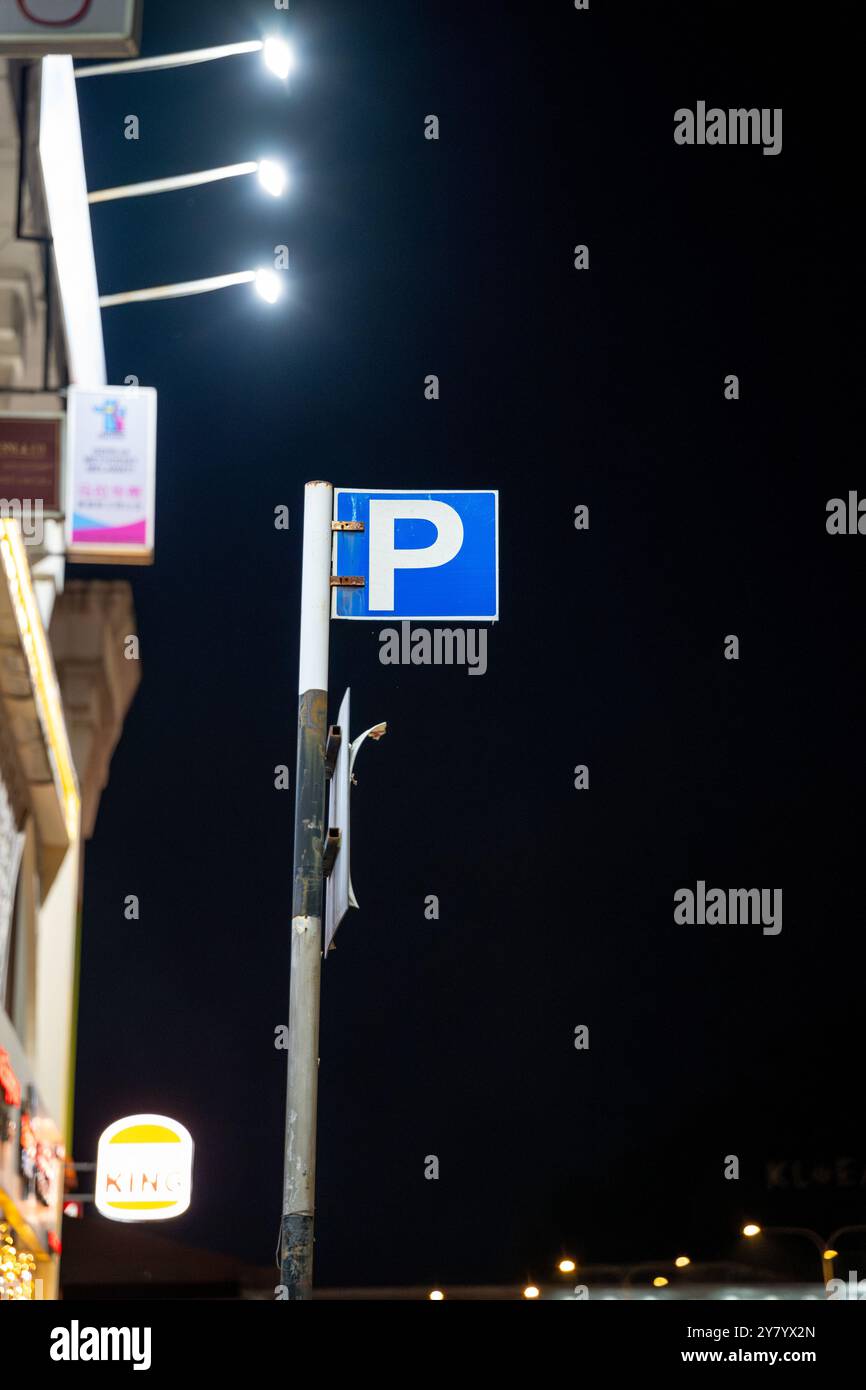 Illuminated Urban Street Parking Sign at Night Stock Photo - Alamy