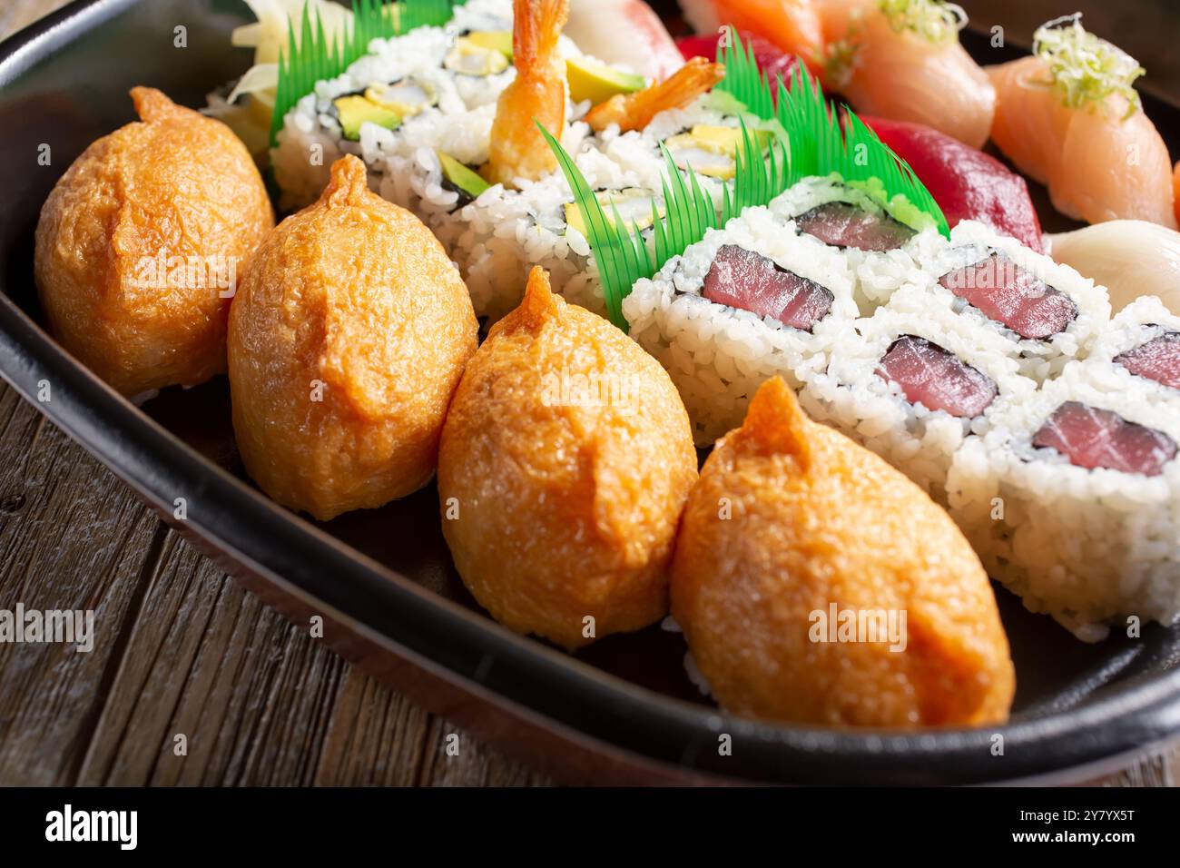 A view of a sushi platter, featuring several pieces of inari Stock ...