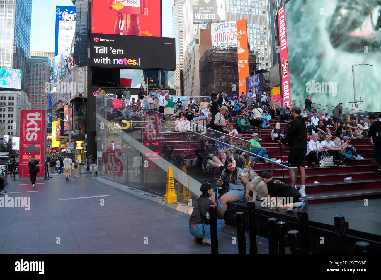 New York, United States. 30th Sep, 2024. People sit on a red staircase ...