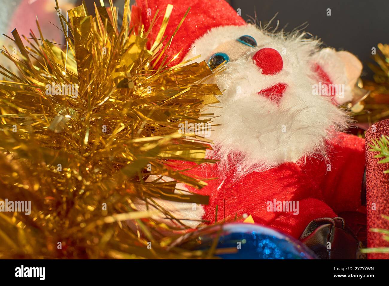 Santa Claus plush toy sitting amidst a festive Christmas scene. The ...