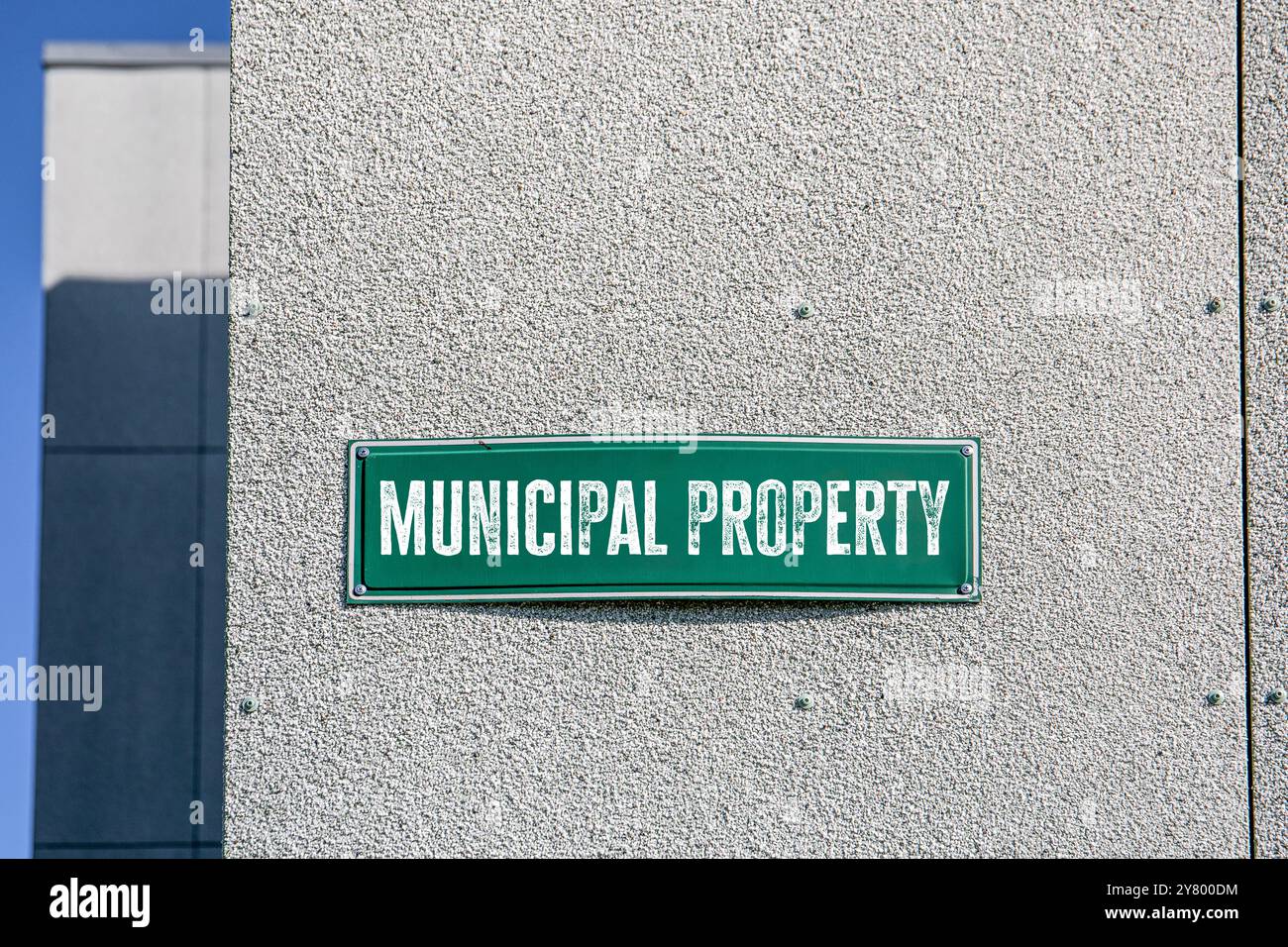 Municipal Property. Green street name plate on the wall of the building ...