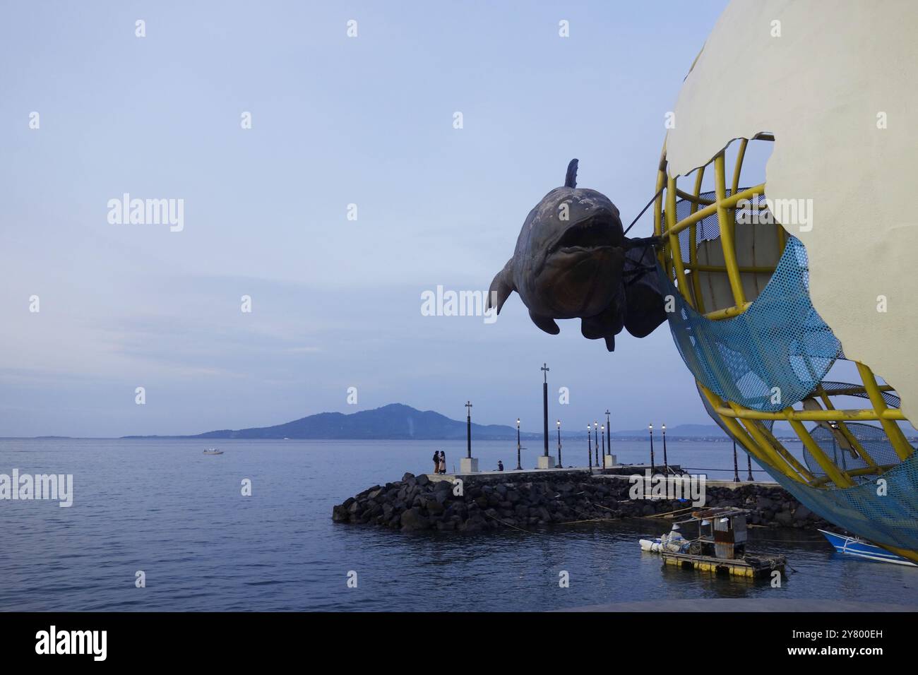 Statue featuring coelacanths with Bunaken Island in background, Manado ...