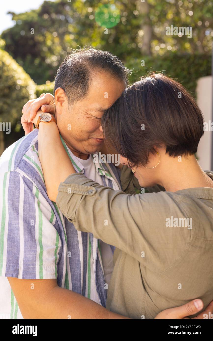 Embracing, multiracial middle-aged couple sharing moment outdoors Stock ...