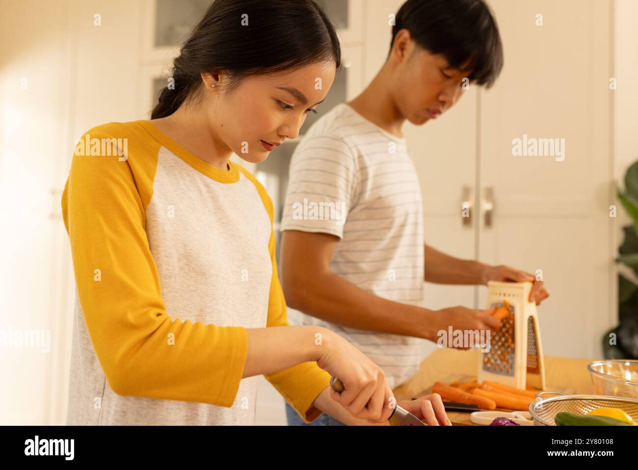 Cooking together in kitchen, young asian brother and sister preparing ...