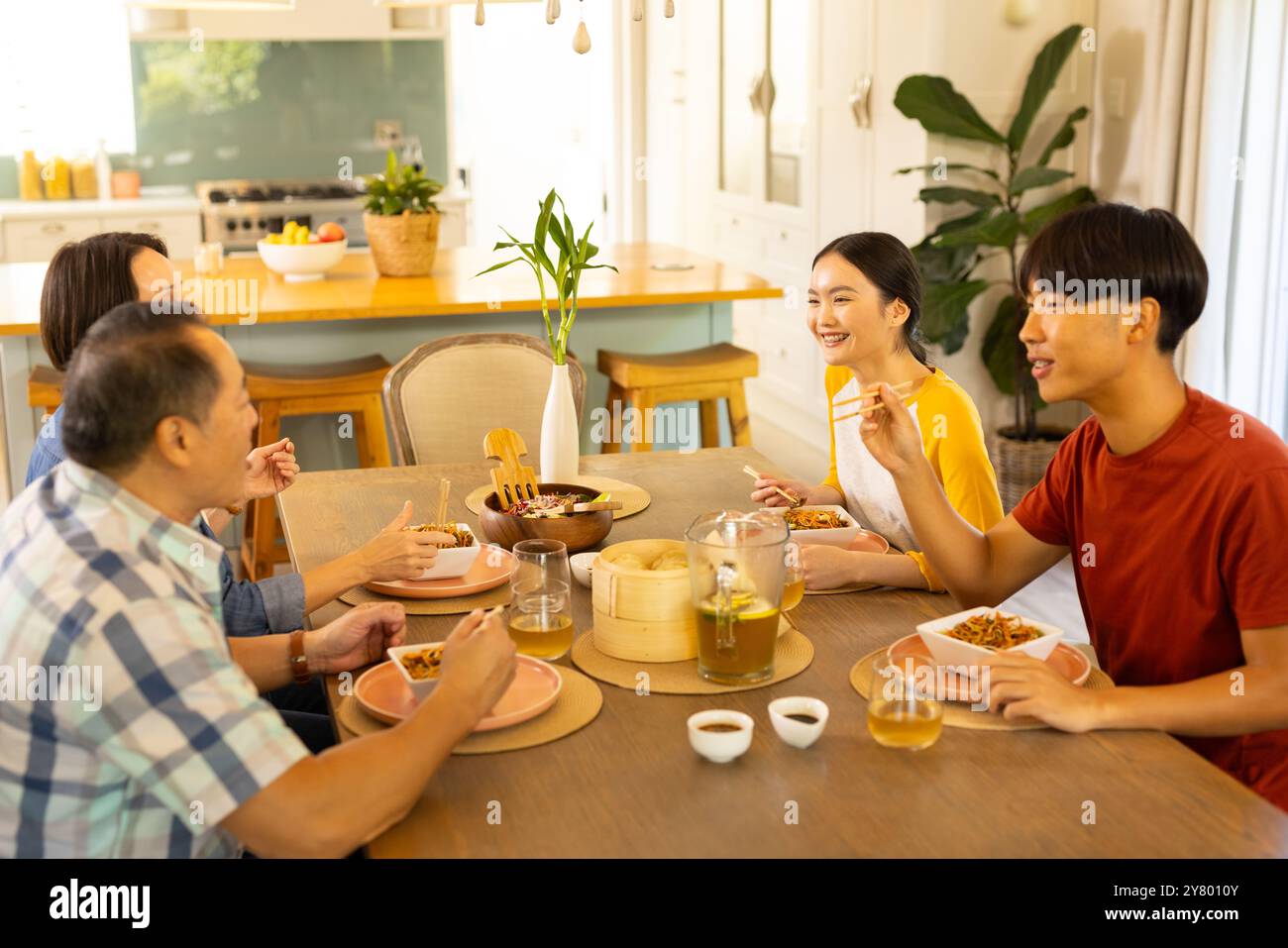 At home, Eating together, asian family enjoying meal and conversation ...