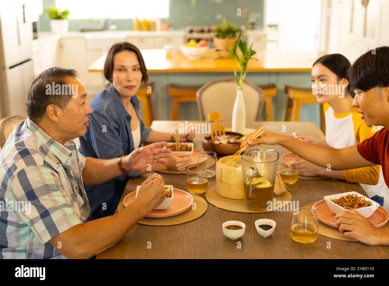 At home, Eating together, asian family enjoying meal and conversation ...
