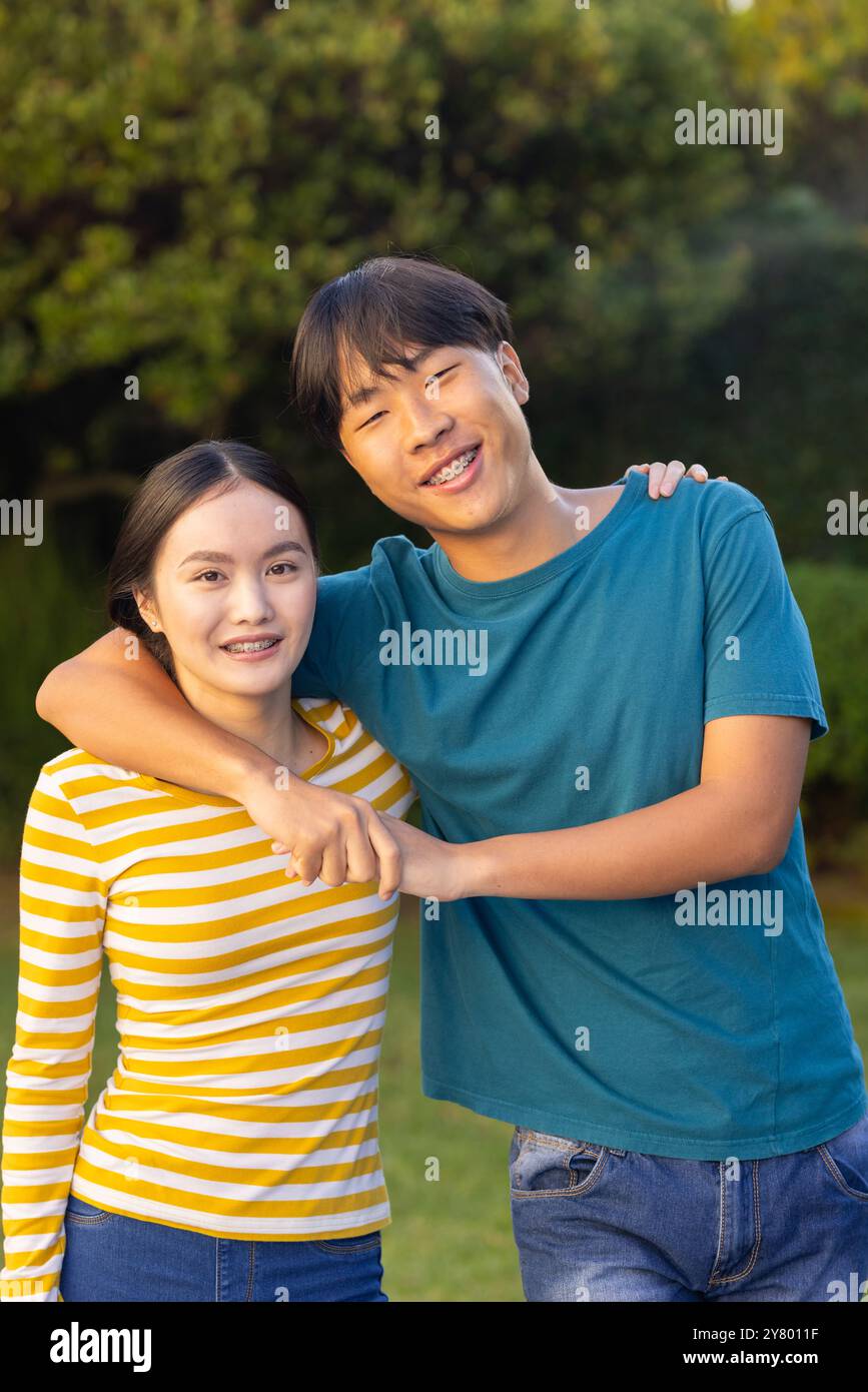 Smiling young asian brother and sister hugging and posing together ...