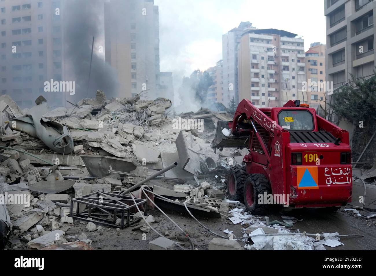 Civil Defense remove debris from a destroyed complex hit in Israeli ...
