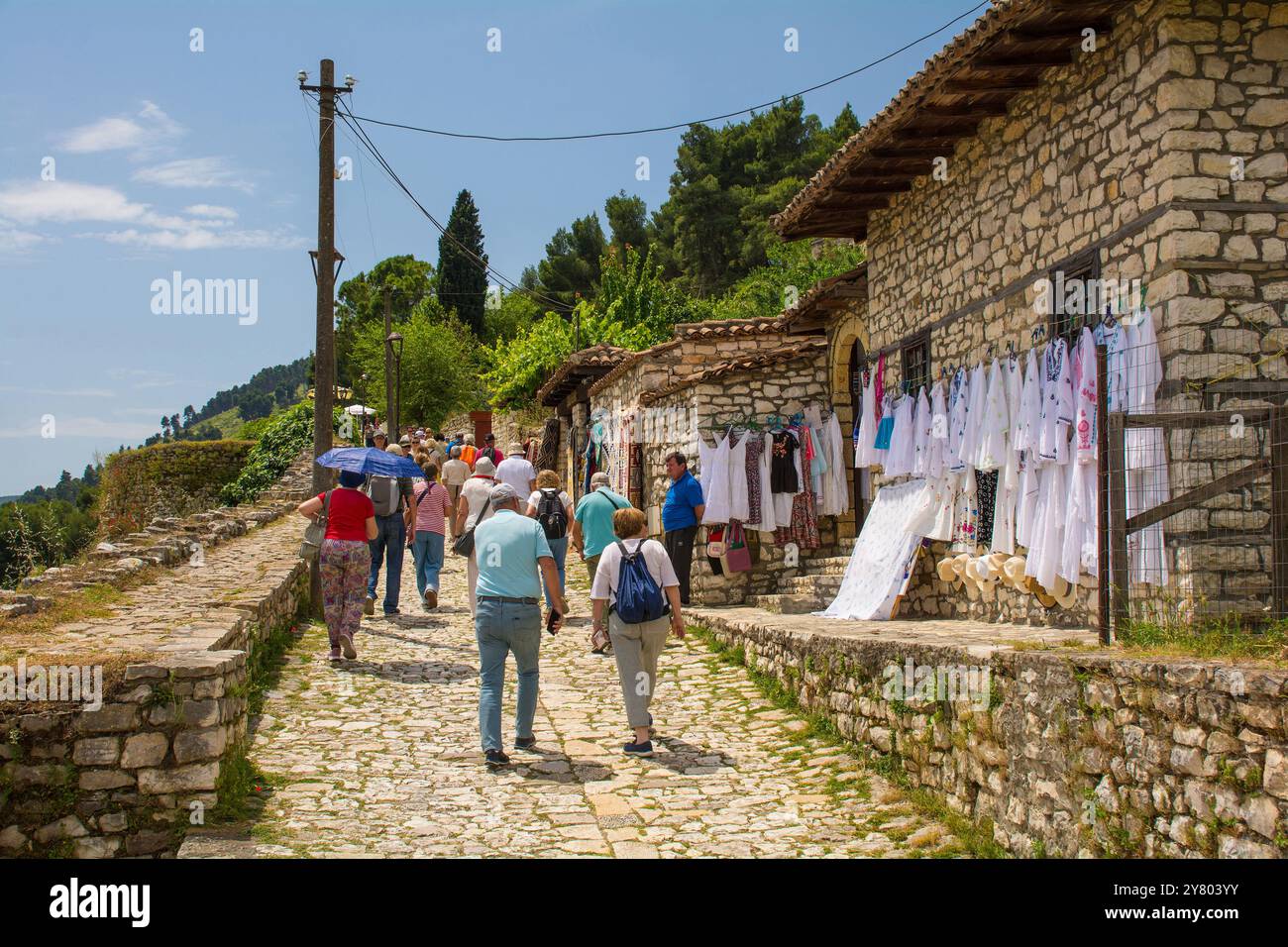 Berat, Albania - June 2 2024. Visitors walk past fabric souvenir items ...