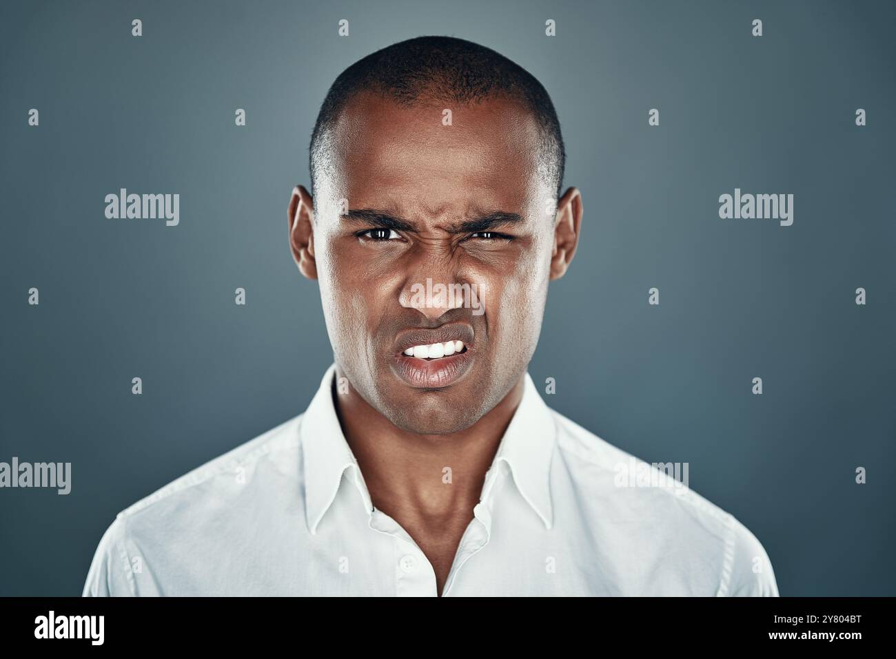 Disgust. Young African man in shirt looking at camera and frowning ...