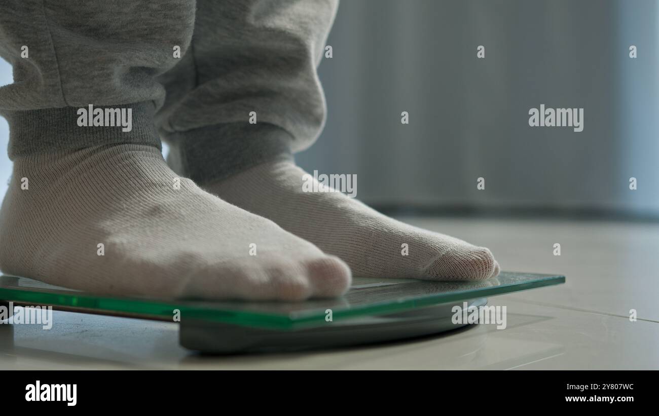 Man feet scales measuring losing weight male legs weighing stepping ...