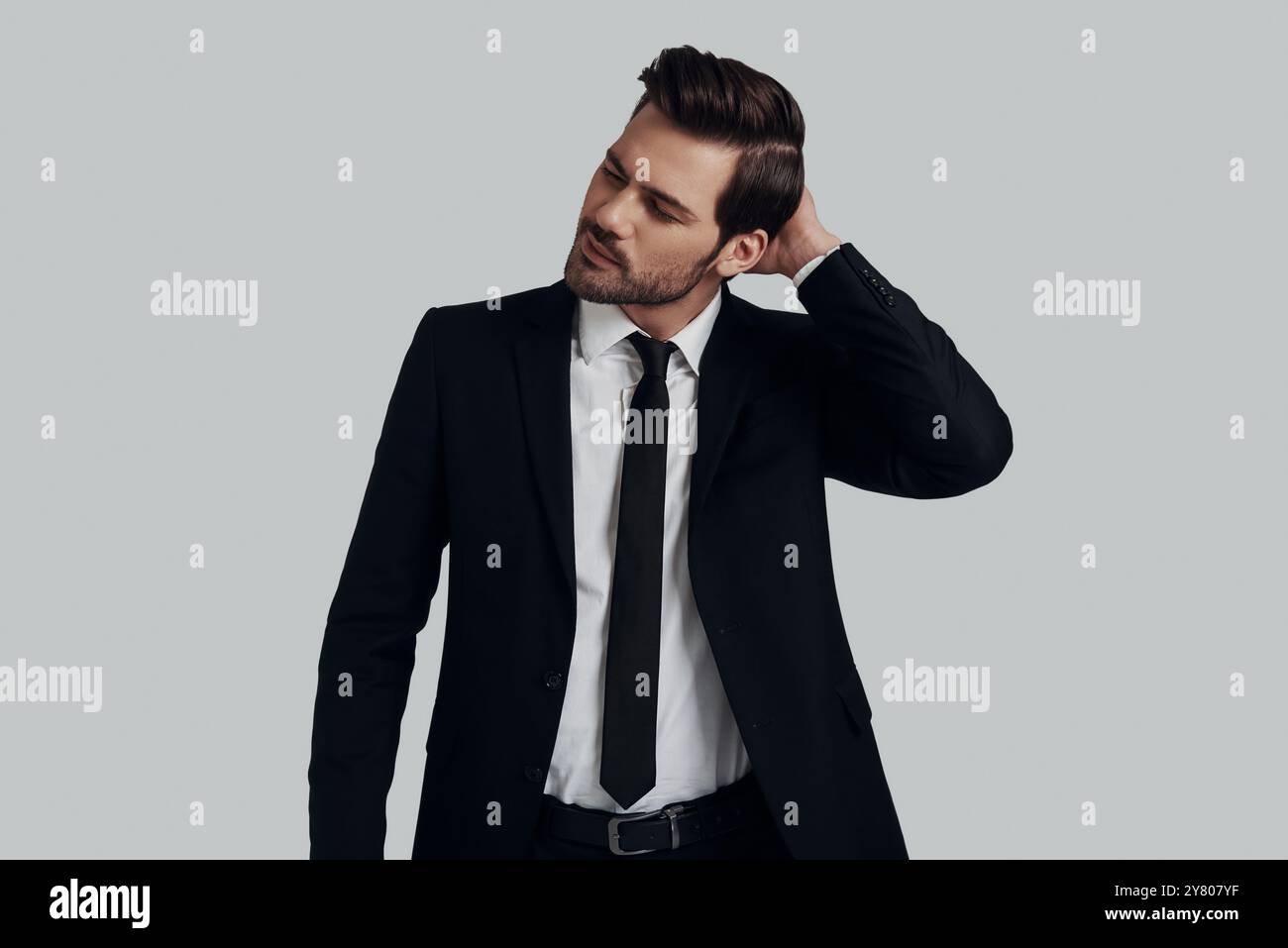 Time to overthink this. Handsome young man in full suit smiling while ...