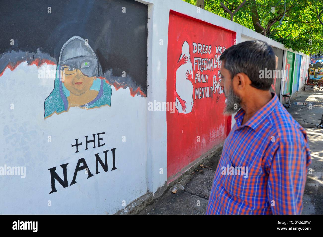 Pedestrian walking by painted graffiti walls in Sylhet town. Where it ...