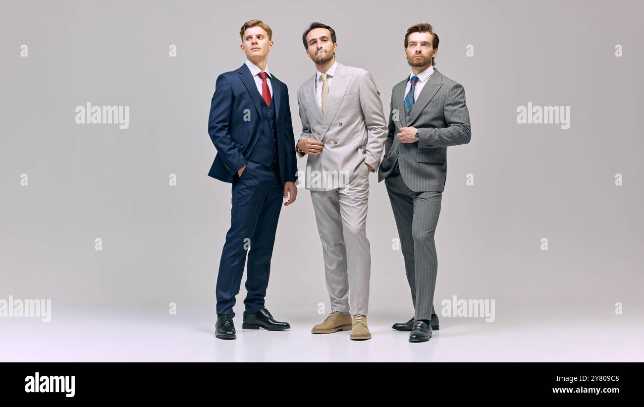 Three young man standing poised, each displaying individual style ...