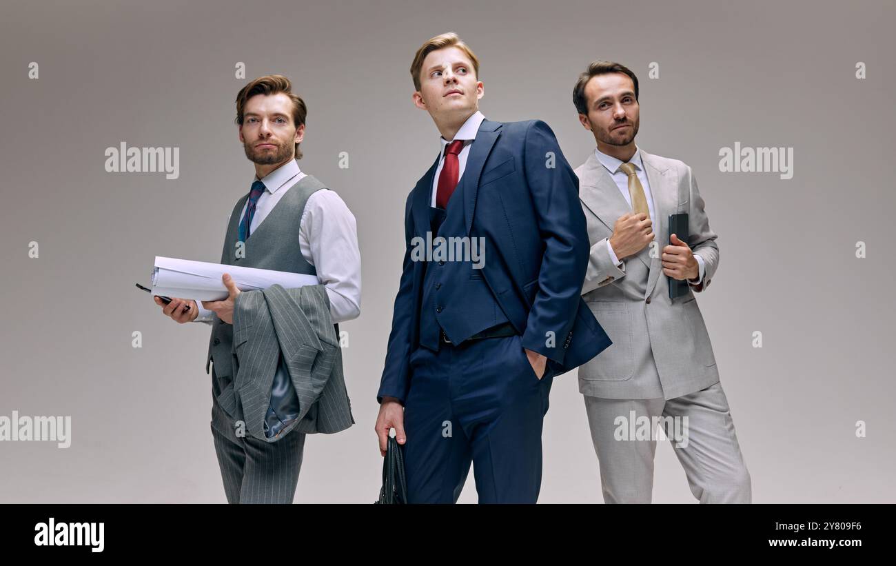 Group of men standing together, holding work items. Dynamic team at ...