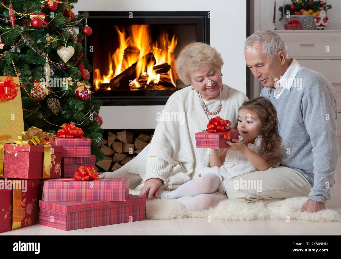 Little girl getting Christmas gift from her grandparents Stock Photo ...