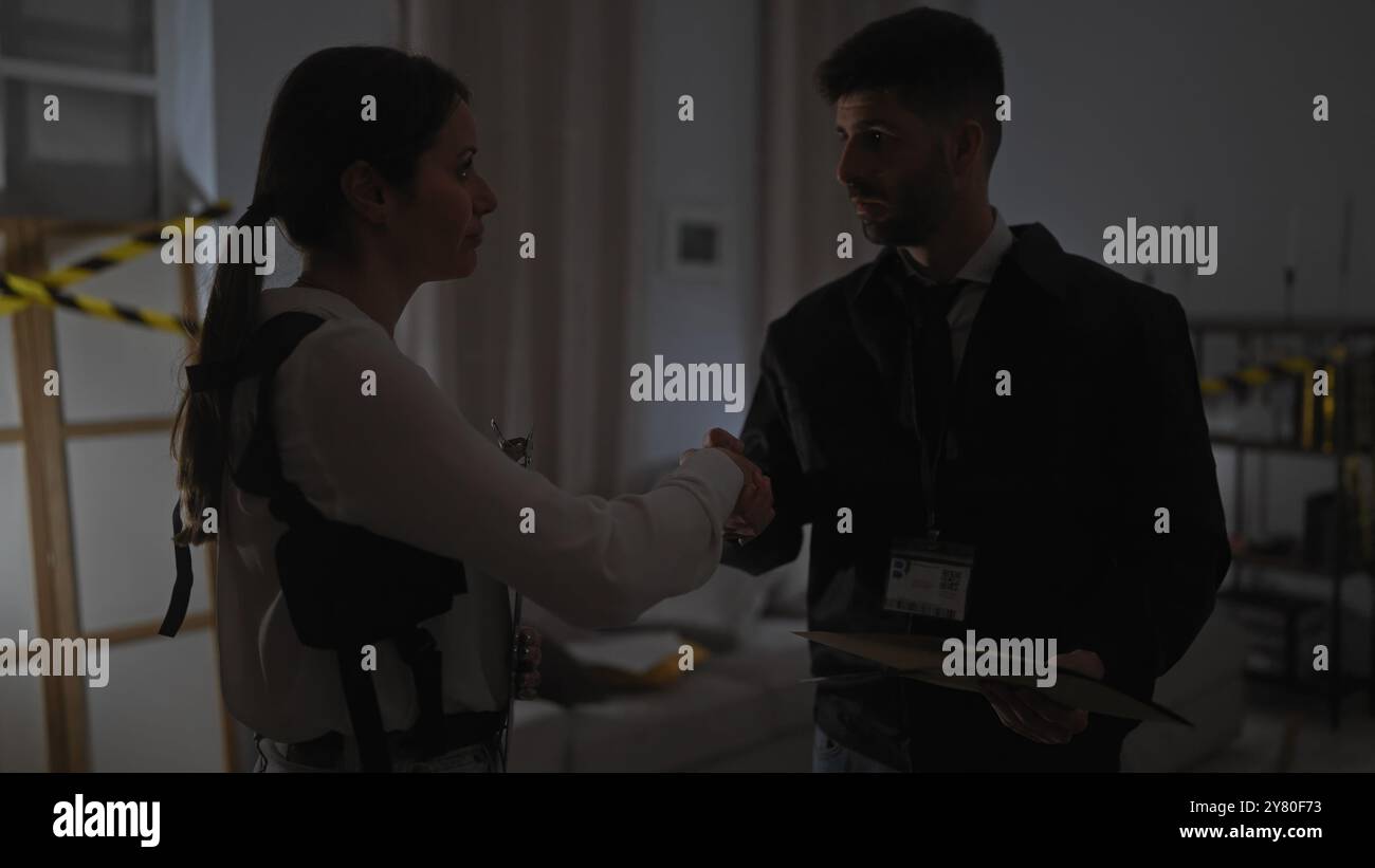 A man and woman, depicted as detectives, shake hands at an indoor crime ...