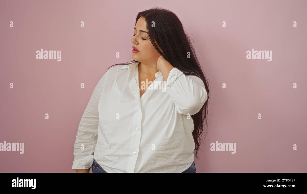 Beautiful plus size woman in a white shirt over an isolated pink ...