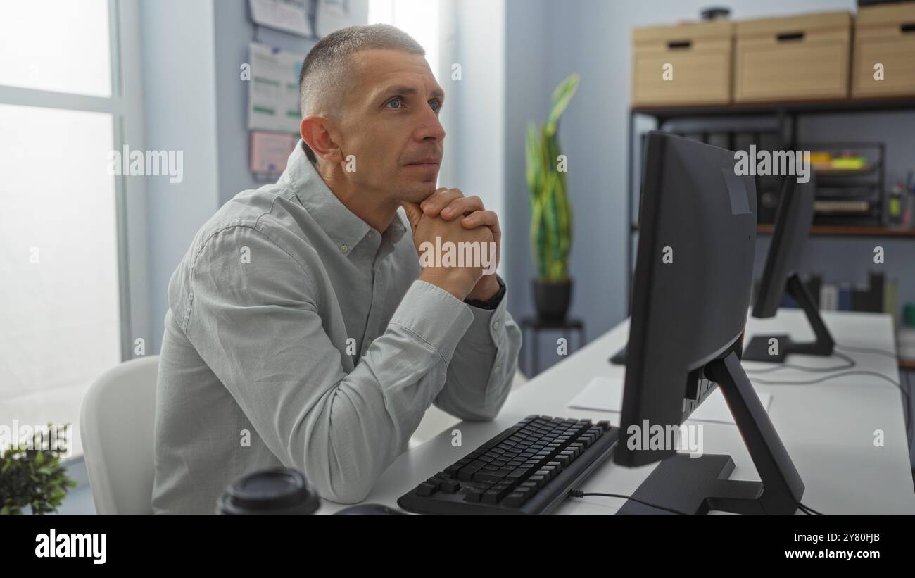 Man working alone in office, thinking, focused on computer, under ...