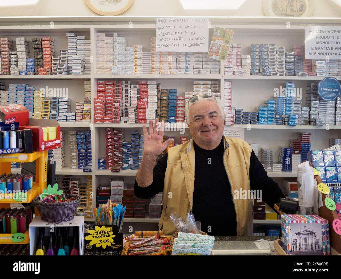 Mantua, Italy September 30th 2024 Senior smiling tobacconist waving ...