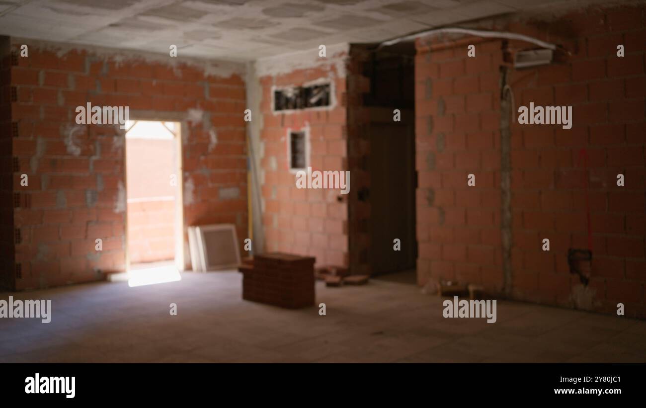 Blurred indoor construction site with unfinished walls and scattered ...