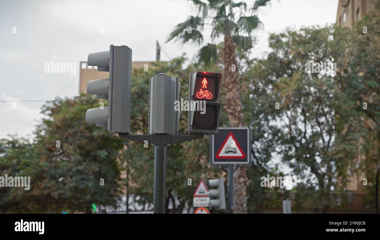 A red pedestrian traffic light amidst greenery in murcia, spain ...